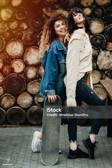 전체 길이 초상화 재미 및 Possing 및 스케이트 보드를 들고 카메라에 두 명의 아름 다운 여자 친구의 2명에 대한 스톡 사진 및 기타 이미지 Istock