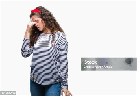 아름 다운 갈색 머리 곱슬 머리 젊은 소녀 코와 눈 피로 두통 느낌 바르고 피곤된 격리 된 배경 위에 줄무늬 스웨터를 입고 스트레스와 좌절 개념입니다 갈색 머리에 대한 스톡