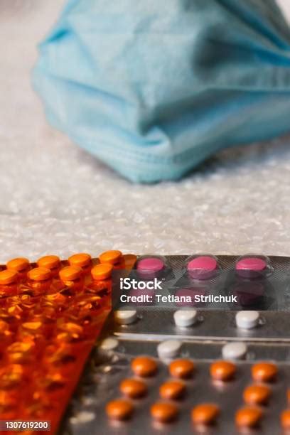 파란 의료 마스크에 얼굴의 Defocus 은유는 다른 알 약의 물집을 본다 바이러스 및 전염병 검역 개념 치료의 개발 세로로