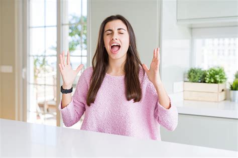 아름 다운 젊은 여성이 분홍색 스웨터를 입고 미친 소리와 소리 공격적인 표정과 팔을 제기 했다 좌절 개념입니다 가정 생활에 대한 스톡 사진 및 기타 이미지 Istock