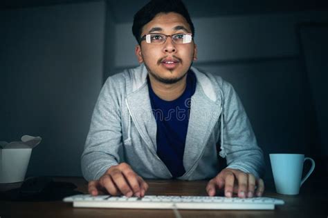 Coding Until Late A Young Man Working On His Computer Late At Night