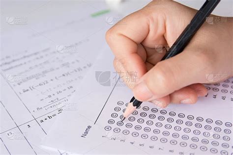 学生手持铅笔在答题纸和数学问题纸上写下选定的选项。学生考试做考试。学校考试素材 花瓣网