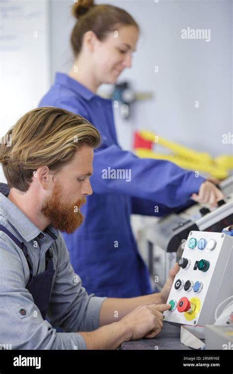 Engineer Instructing Female Apprentice On Use Of Cnc Machine Stock Photo Alamy