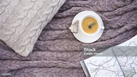 회색 베개와 따뜻한 모직 회색 분홍색 무늬에 여행 하는 지도 책의 형태로 전나무와 화이트 페이지에서 와플 쿠키와 화이트 컵 커피 니트 직물 끈 패턴입니다 겨울이을 개념 편안