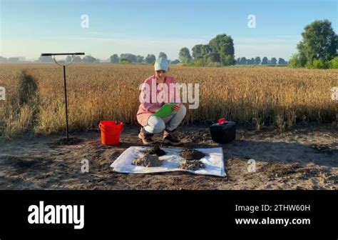 Woman Agriculturist Performing Soil Analysis Taking Notes In Sample Information Sheet At Grain