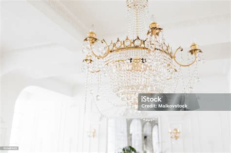 비싼 인테리어입니다 투명 한 유리 구슬의 큰 전기 샹들리입니다 흰색 천장 치장 벽 토 조형 장식 흰색 꽃무늬입니다 석고에서 조형