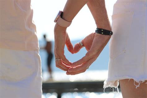 Dos personas cogidas de la mano con las manos en forma de corazón Foto Premium