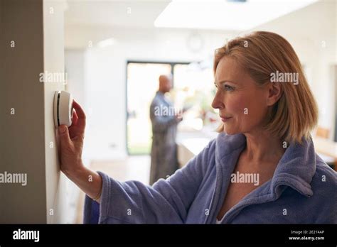Mature Woman Turning Control Dial On Digital Central Heating Thermostat At Home Stock Photo Alamy