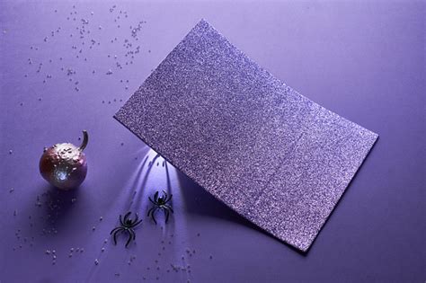 빛나는 종이 카드 아래 긴 그림자를 따라 기어 다니는 거미와 두 개의 빛나는 호박 화가 금속 색상과 창조적 인 보라색 할로윈 모형 복사 공간 0명에 대한 스톡 사진 및 기타