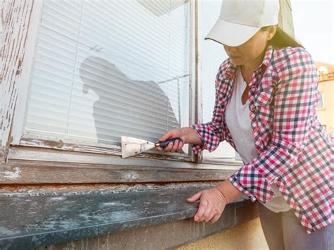Premium Photo Women Remove The Old Layer Of Paint With A Wooden Window Using A Spatula