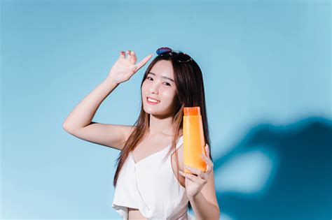 매력적인 아시아 뷰티 우먼은 파란색 배경에 자외선 차단 Uv 또는 자외선 차단제로 선크림과 컬러 스케일을 들고 있습니다 18 19세에 대한 스톡 사진 및 기타 이미지