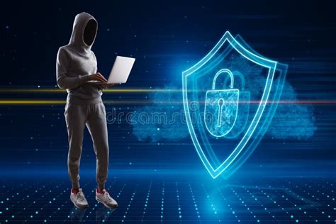 hacker in hoodie standing and using laptop with glowing shield hologram