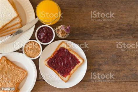 오렌지 주스와 토스트 빵 집에서 만든 딸기 잼 땅콩 버터와 함께 제공 됩니다 아침 식사 테이블에 땅콩 버터와 잼의 수 제 토스트 빵 상위 뷰 평면에 맛 있는 토스트 빵이