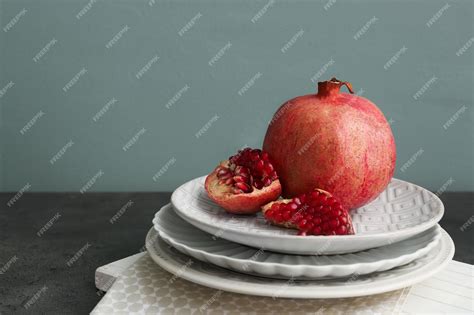 Premium Photo Stack Of Plates And Pomegranate On Table