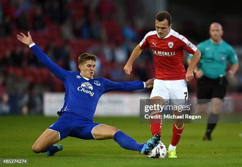 John Stones Of Everton Tackles Josh Scowen Of Barnsley During The