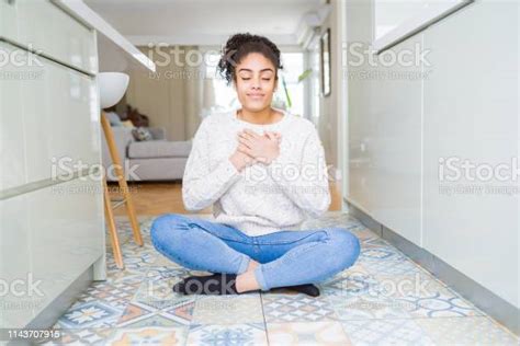 얼굴에 닫힌 눈과 감사 제스처와 가슴에 손으로 웃 고 바닥에 앉아 아프리카 머리와 아름 다운 젊은 아프리카계 미국인 여자 건강 개념입니다 감사에 대한 스톡 사진 및 기타