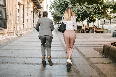 전기 푸시 스쿠터로 일하고 웃고 재미있게 지내는 두 명의 사업가 지속 가능한 운송 20 24세에 대한 스톡 사진 및 기타 이미지 20 24세 2명 30 34세