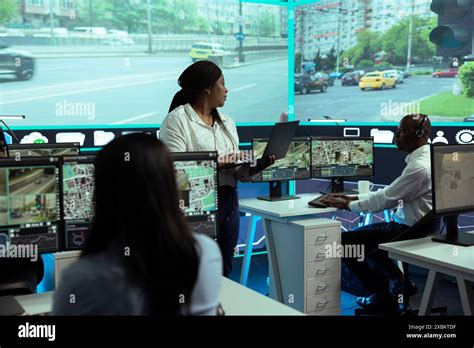 Diverse Employees Monitoring Urban Traffic In Control Center Agency Following Cars And Their