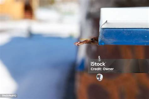 파란색 제본용 여백 및 눈이 흐린 배경에 물 한 방울의 형태로 흐르는 용 해 배수 통이 흐르는 물방울을 닫습니다 봄에 집 마당에 0명에 대한 스톡 사진 및 기타 이미지