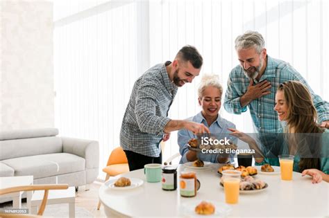 실내에서 함께 식사하는 행복한 가족 아침 식사 중에 식탁에 앉아 웃는 세대 가족 거실에서 함께 식사를 즐기는 행복한 쾌활한 가족 4 명에 대한 스톡 사진 및 기타 이미지