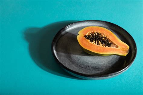 블루 파스텔 배경에 회색 접시에 잘 익은 잘라 파파야 측면 보기 복사 공간 하드 라이트 열대 건강한 음식 여성 건강 개념 미니멀리즘 접시에 대한 스톡 사진 및 기타 이미지