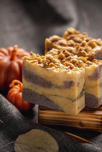 수제 향기로운 천연 비누와 호박 모양의 양초가 어두운 배경에 노란색 마른 잎으로 아늑한 분위기를 조성합니다 아름다운 가을 엽서