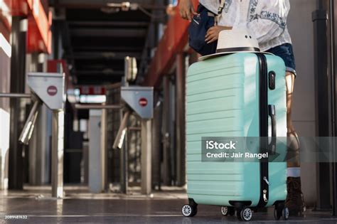 버스 정류장이나 터미널에서 여행 가방을 들고 여행 중 교통편을 기다리는 여성 승객의 복사 공간이 있는 사진 20 29세에 대한