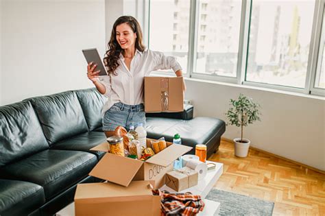 가난한 사람들을위한 디지털 태블릿및 포장 기부 상자를 사용하는 젊은 여성 가정 생활에 대한 스톡 사진 및 기타 이미지 가정