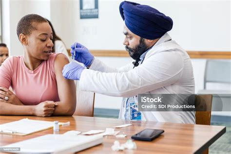 건강 페어에서 의료 자원봉사로부터 여성이 예방접종을 받고 있다 라틴 아메리카 히스패닉 민족에 대한 스톡 사진 및 기타 이미지 라틴 아메리카 히스패닉 민족 백신접종