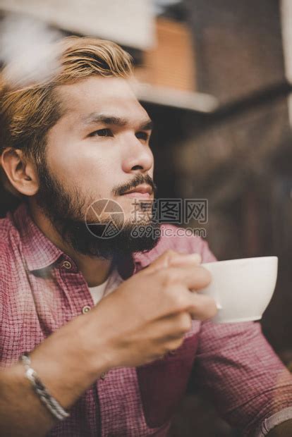 年轻人坐在咖啡馆的酒吧喝咖啡时眼高清图片下载 正版图片505176443 摄图网