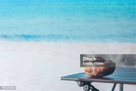 바다가 보이는 해변에서 코코넛 그릇에 담긴 손 왕실 의자 에 들고 있는 밀짚 모자를 쓴 여성 건강한 식생활에 대한 스톡 사진 및 기타 이미지 Istock