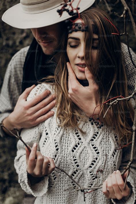 세련된 스카프를 두른 잘생긴 카우보이 남자가 보헤미안 화이트 스웨터를 입고 입술을 만지며 가을 나무 근처에서 포즈를 취하고 있다 사진 Unsplash의 우크라이나 이미지