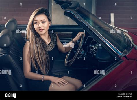 Attractive Girl Sitting In Classic American Muscle Car Parked On The