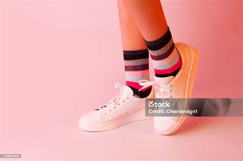 패션 흰색 가죽 운동화 다채로운 줄무늬 양말과 소녀 다리 파스텔 핑크 배경의 신발 무료 복사 공간이 있는 레이아웃입니다 양말에 대한 스톡 사진 및 기타 이미지 Istock