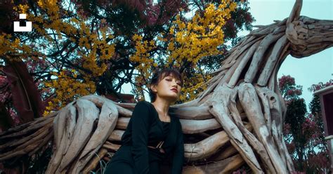 긴 검은 드레스를 입은 여성이 말 조각상 옆에 서 있습니다 사진 Unsplash의 무료 유행 이미지