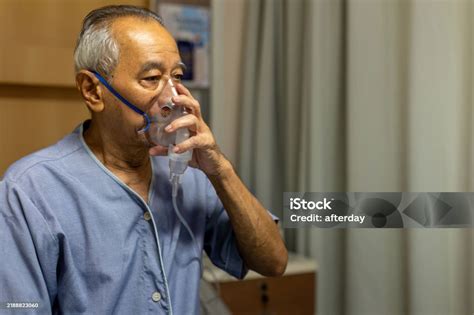 노인 노인은 호흡을 돕기 위해 산소 흡입기 장치를 착용하고 호흡을 돕습니다 환자는 병원에서 휴대용 산소를 사용합니다 호흡기 질환이 있는 환자 휴대용 산소 발생기 또는 산소