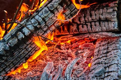 Premium Photo Close Up Of Ash Covered Logs With Yellow And Orange Flames And Red Embers