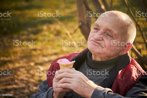 80세 남성이 공원에서 산책하고 와플 컵에 아이스크림을 먹습니다 고독 부정적인 감정 표현에 대한 스톡 사진 및 기타 이미지 고독 부정적인 감정 표현 공원 공원 벤치