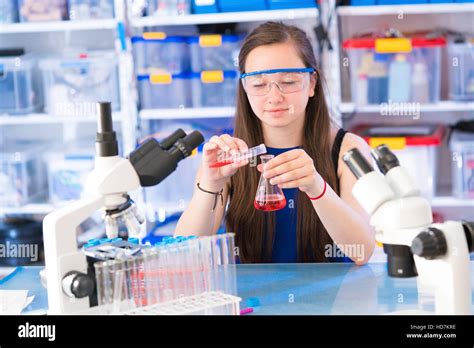 MODEL RELEASED Girl Pouring Liquid Into Chemical Flask In Laboratory Stock Photo Alamy