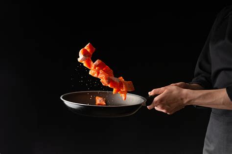 해산물 전문 요리사는 붉은 물고기 연어 송어의 조각을 준비 합니다 공기의 서 리 해산물 요리 건강 한 채식 음식과 어두운 배경에서 음식 가로 보기 고급 요리에 대한 스톡