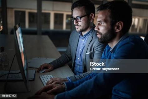 어두운 사무실에서 데스크톱 Pc에서 일하는 두 사업가 컴퓨터 프로그래머에 대한 스톡 사진 및 기타 이미지 컴퓨터 프로그래머