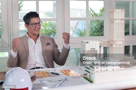 젊은 건축가는 사무실 작업 공간에서 초안 인테리어 청사진 레이아웃 컴퓨터 노트북 헬멧 도구와 건축 건축 모델에 작업 건축에 대한 스톡 사진 및 기타 이미지 Istock