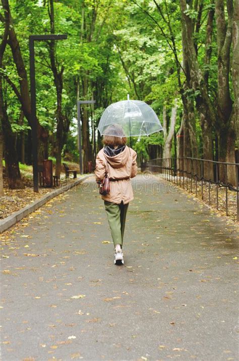 Young Happy Woman Walking In The Rain In Green Park With Umbrella