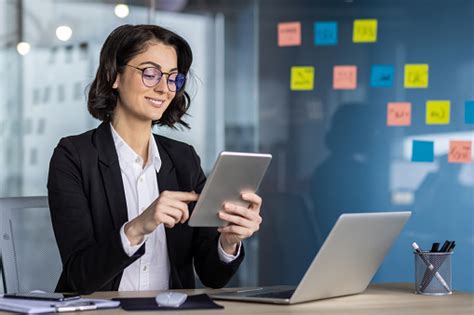 현대적인 사무실에서 태블릿을 사용하는 자신감 넘치는 사업가와 스티커 메모와 노트북을 볼 수 있습니다 개발에 대한 스톡 사진 및 기타 이미지 Istock