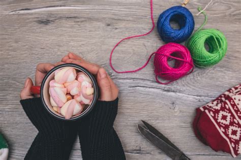 크리스마스 선물 또는 선물 상자와 함께 커피 잔을 들고 여자 손 크래프트 종이에 싸여 크리스마스 나무 나뭇 가지 상단보기로 장식