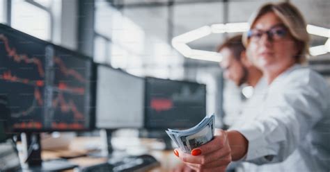 월급을 가져 가라 모니터 근처에 돈을 들고 있는 여자의 손을 그래프로 클로즈업한다 사진 Unsplash의 주식 시장 및 거래소 이미지