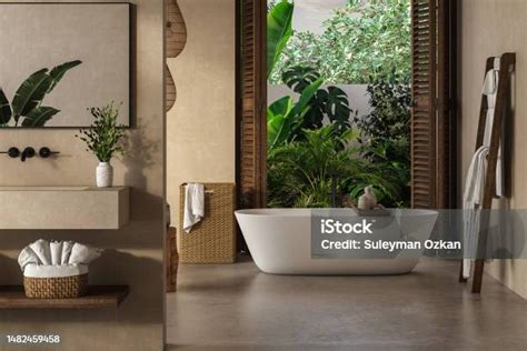 베이지색 벽이 있는 넓은 욕실 아름다운 화장대 검은색 프레임 거울 펜던트 램프 수건 바구니 흰색 욕조 녹지가 있는 정원의 고요한 전망 3d 렌더링 균형에 대한 스톡 사진 및