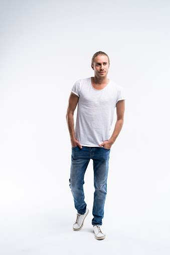 흰색 배경에 대해 카메라를보고 청바지와 티셔츠에 귀여운 젊은 남자의 전체 길이 T 셔츠에 대한 스톡 사진 및 기타 이미지 T 셔츠 가득 찬 남자 Istock