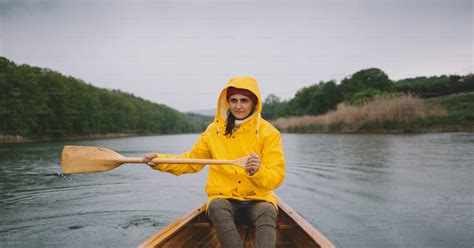 노란 비옷을 입은 소녀가 카누를 노를 젓고 있다 빗속에서 노를 젓는 보트 사진 Unsplash의 우기 이미지