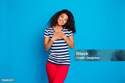 쾌활한 아프로 미국 소녀의 초상화 는 가슴 느낌 내용에 손을 넣어 감사 착용 좋은 찾고 의상 스트라이프 T 셔츠 세련된 트렌디 한 파란색 배경에 고립 T 셔츠에 대한 스톡